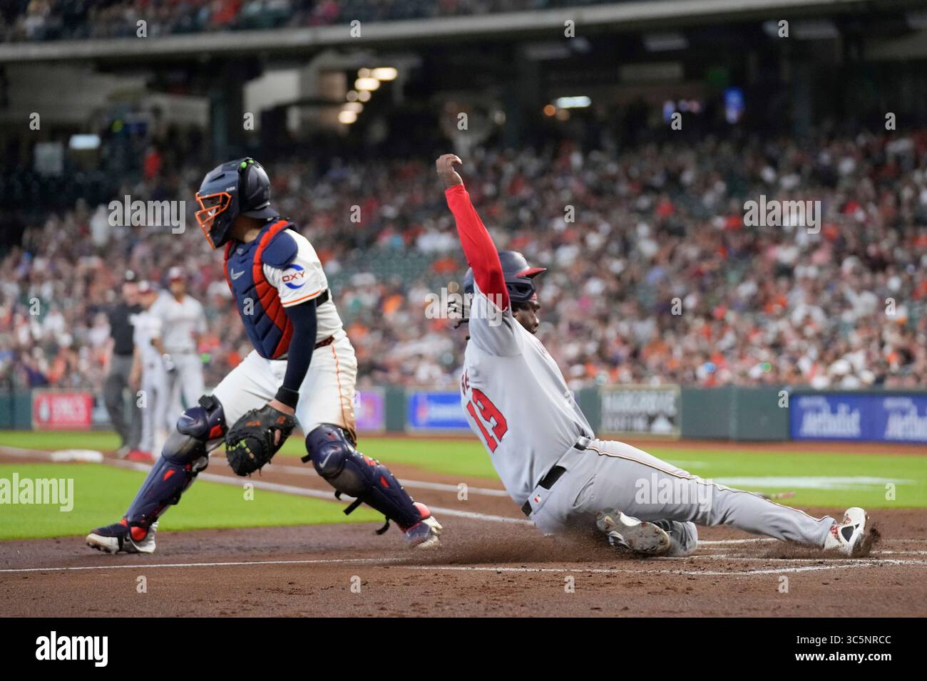 Washington Nationals' Josh Bell (19) slides across home plate as ...