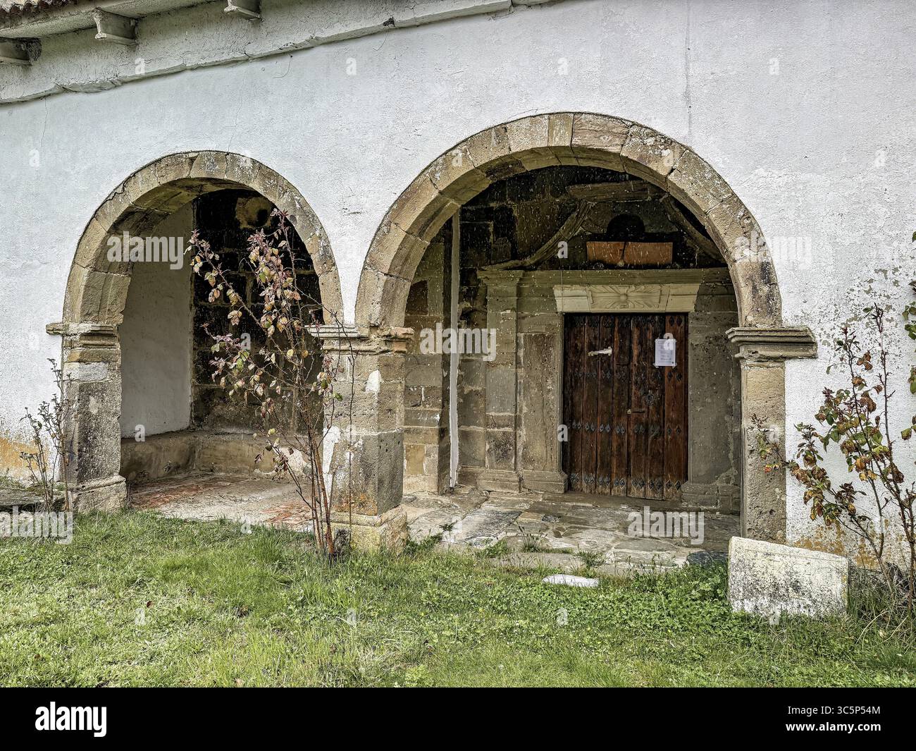 Ancient stone church featuring a bell tower and arched entrance in a ...
