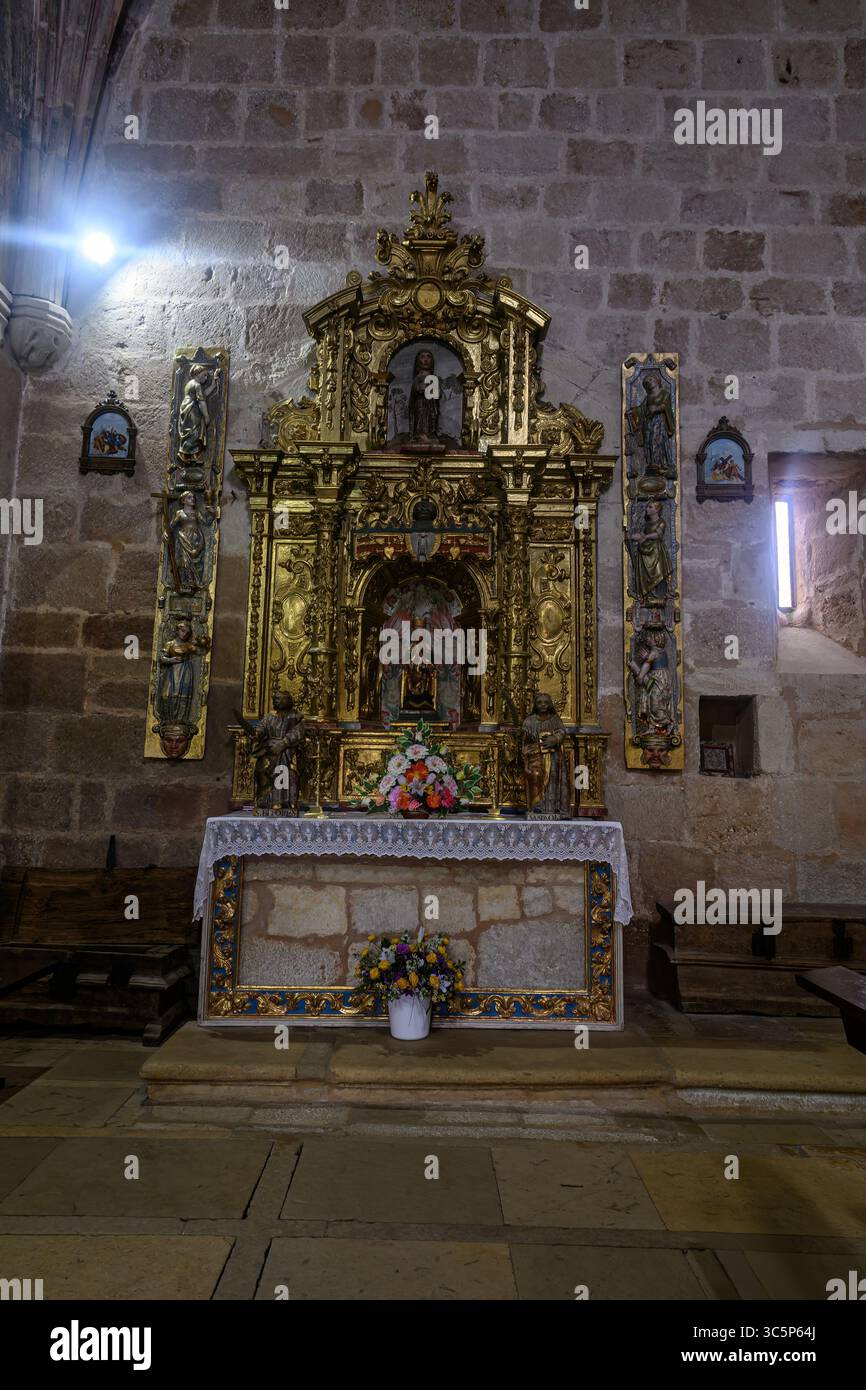 Baroque-style gilded side altar with intricate carvings and saint ...
