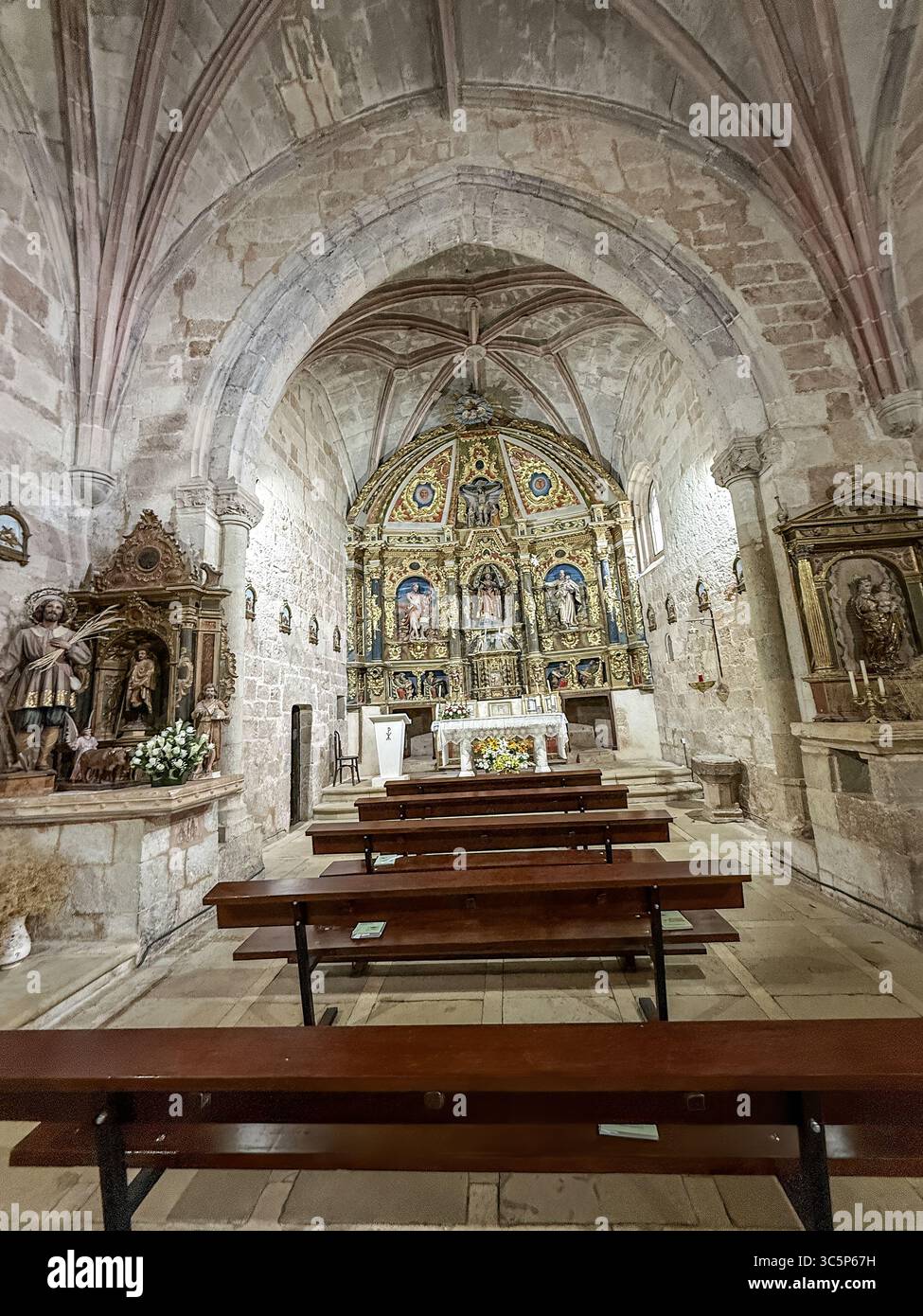 Baroque altarpiece with religious figures under Gothic ribbed vault in ...