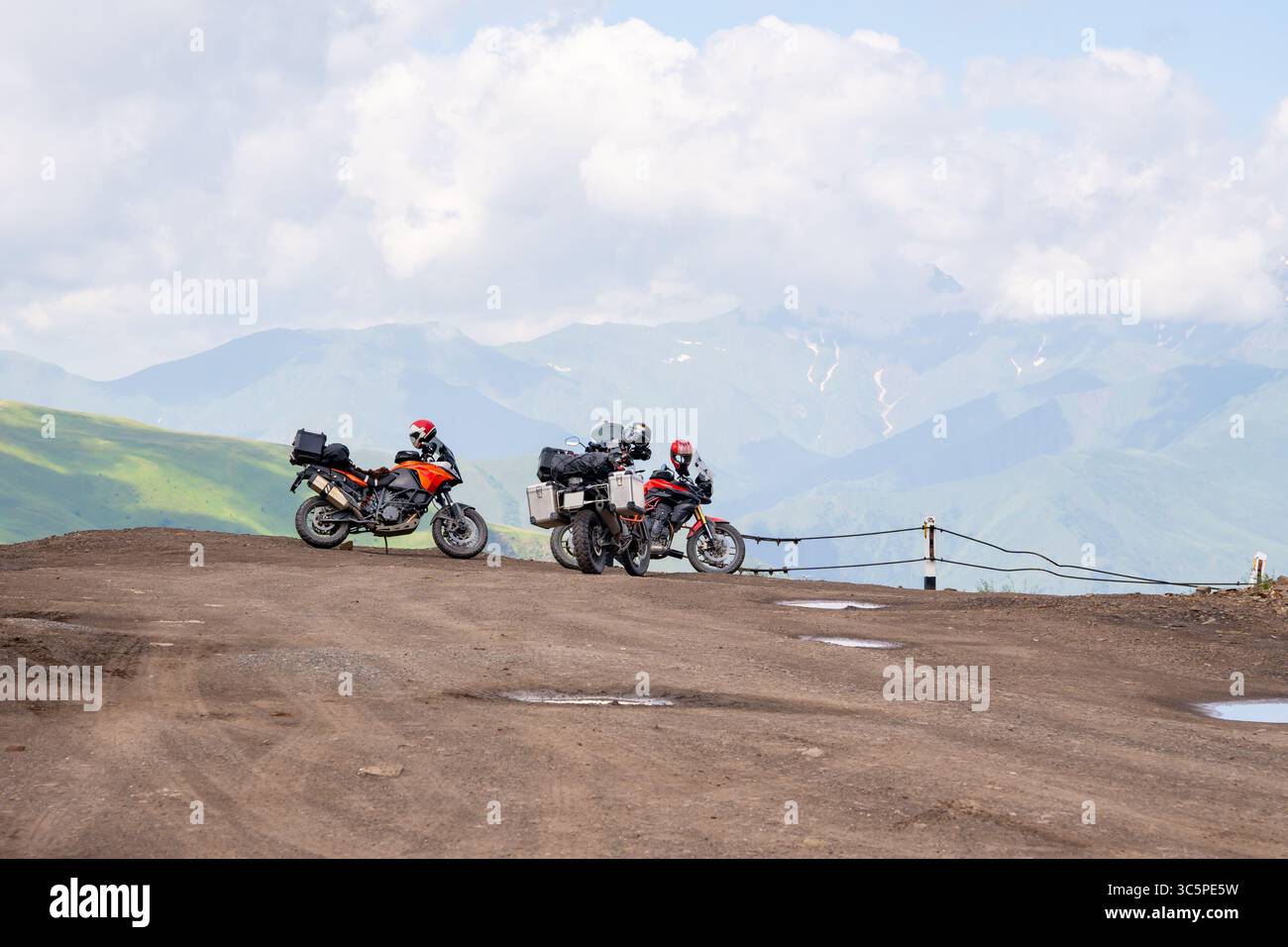 Two touring motorcycles on a high mountain dirt road with a view of the ...