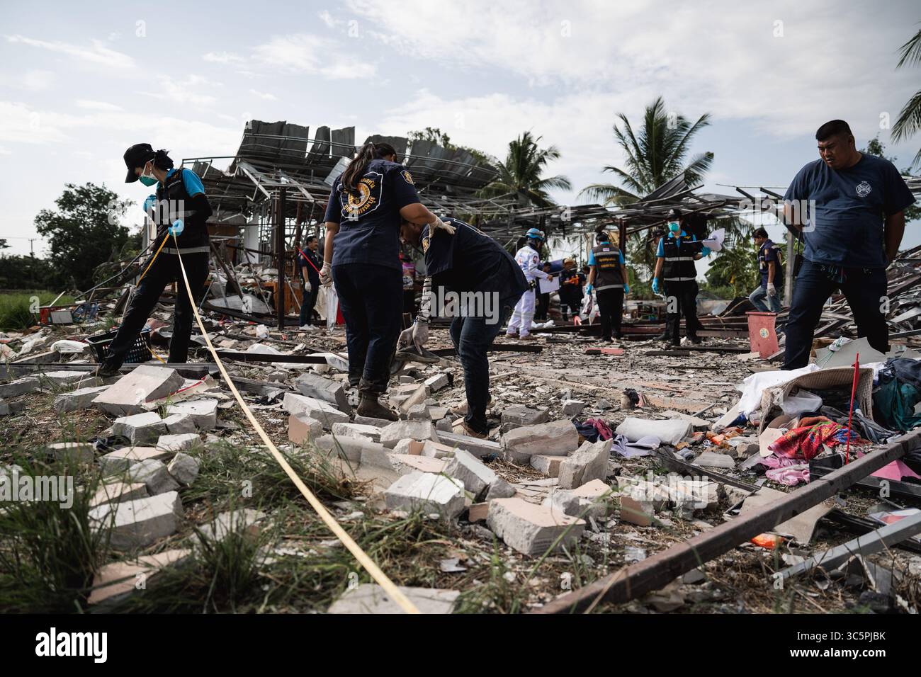 Forensic teams and rescue workers sift through rubble at the site of a ...