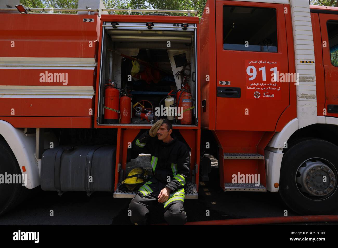 30 July 2025, Iraq, Baghdad: A firefighter takes a rest after ...