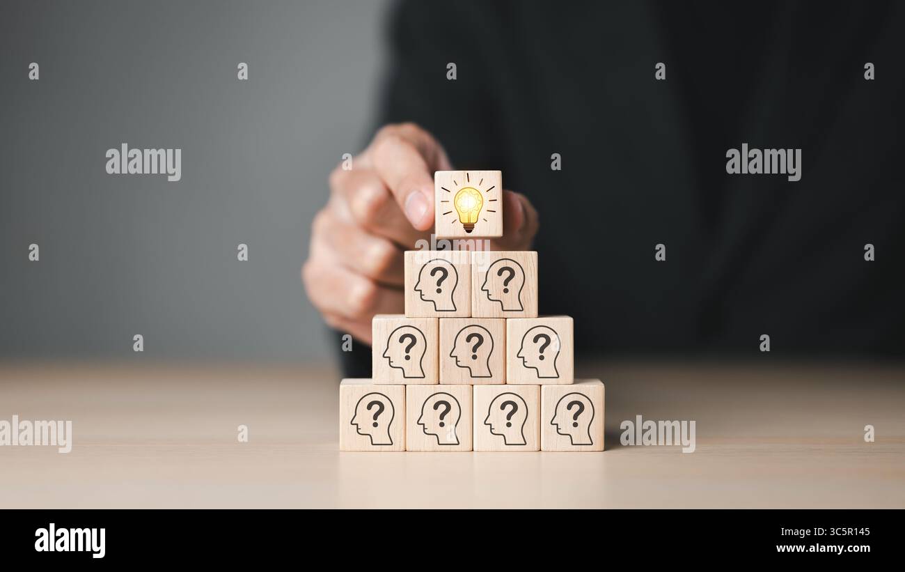 Hand places light bulb icon wooden block into slot with human icon with ...