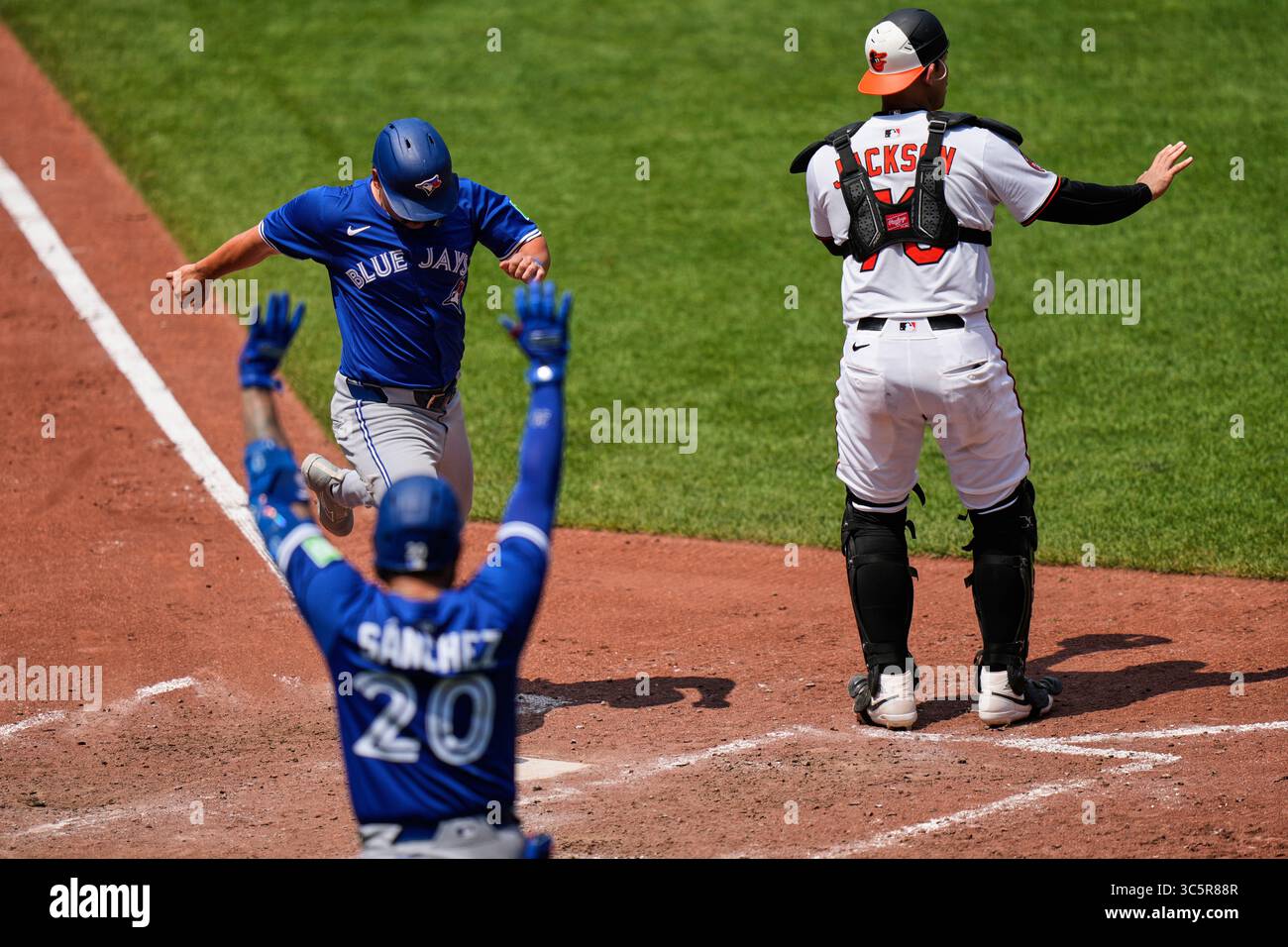 Toronto Blue Jays' Davis Schneider, top left, scores behind Baltimore ...