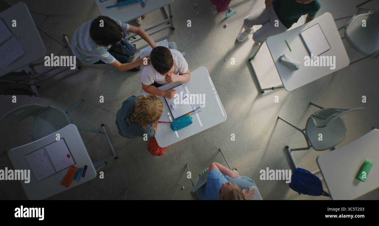 Depressed Primary School Boy Sitting Alone at Desk in Classroom While ...