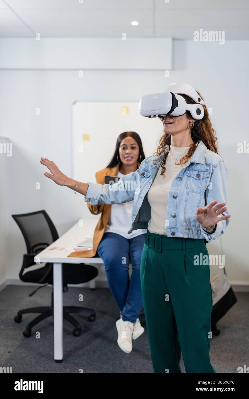 Diverse female coworkers guiding vr hi-res stock photography and images ...