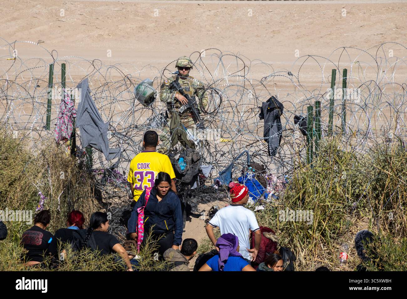 Civilians gather by the fortified border fence in Ciudad Juarez, under ...