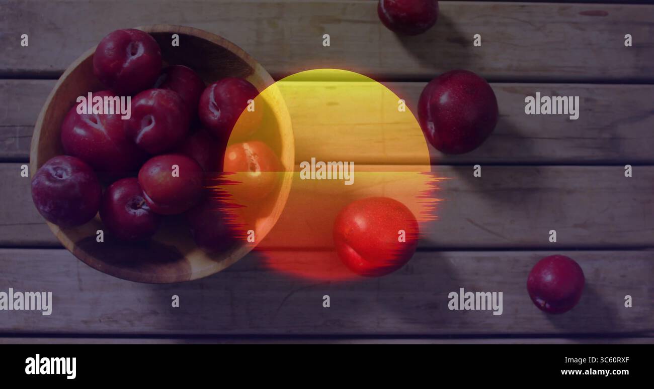 Displaying wooden bowl holding red plums on worn plank table showing ...