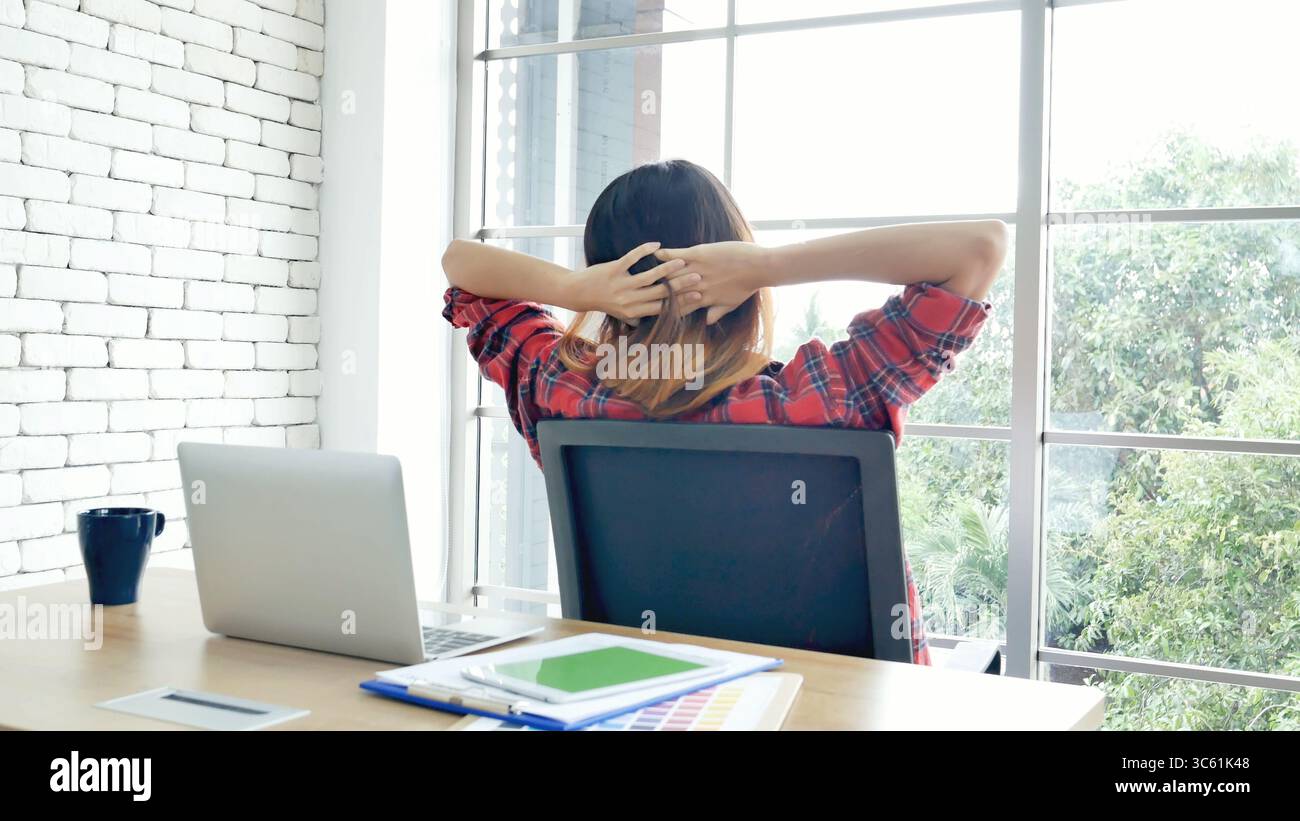 Woman streching arm raised sitting incorrect position home office desk ...