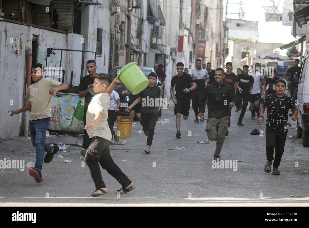 Palestinians confront Israeli army vehicles and throw stones during a ...