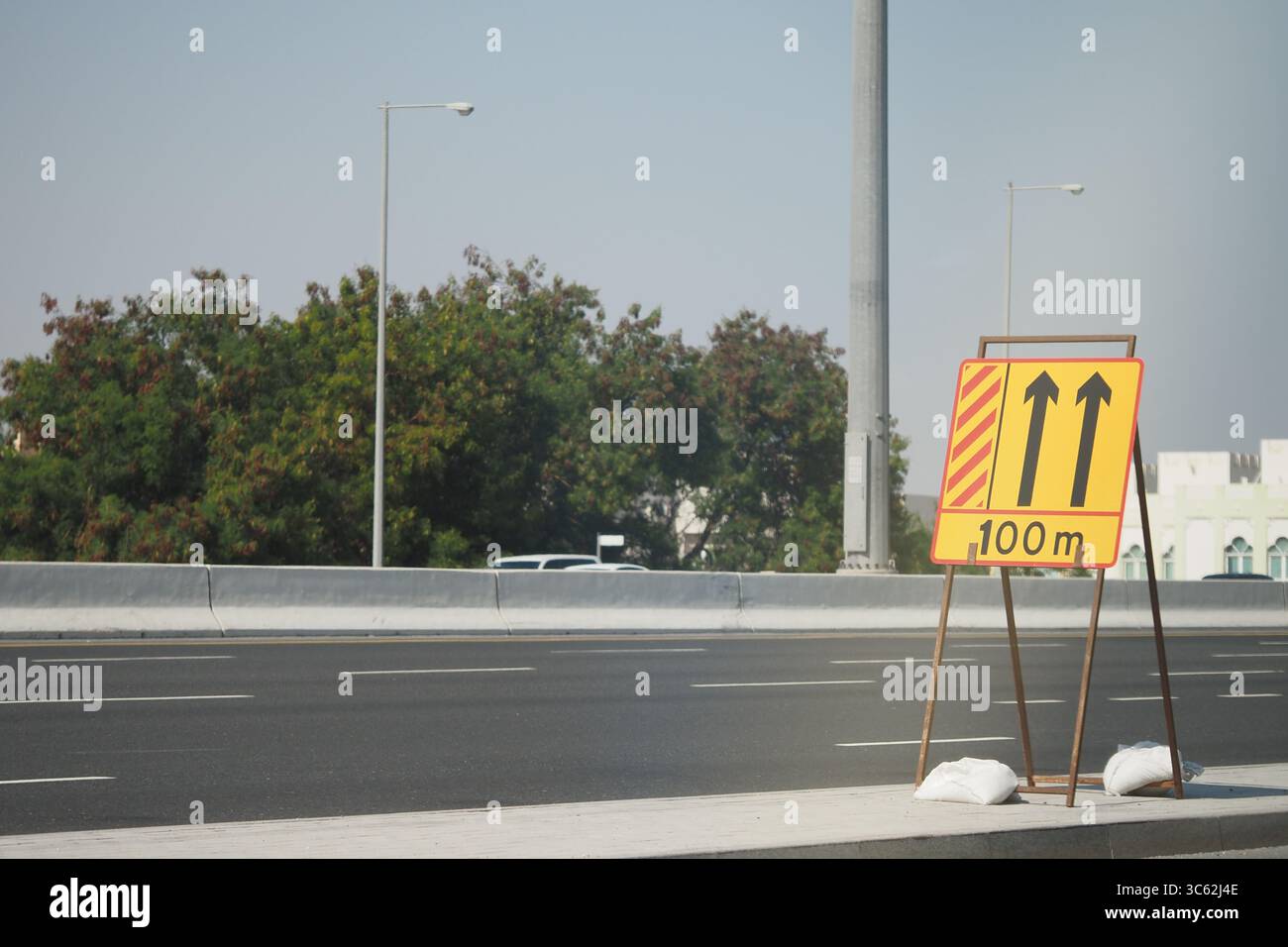 Road sign indicating lane shift 100 meters ahead Stock Photo - Alamy
