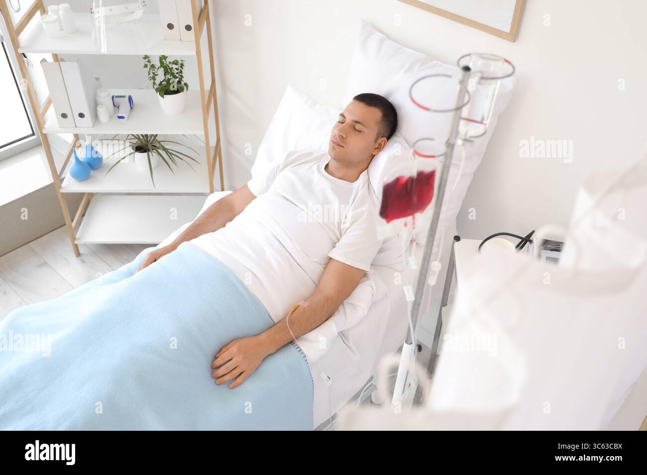 Male patient transfusing blood on bed in hospital ward Stock Photo - Alamy