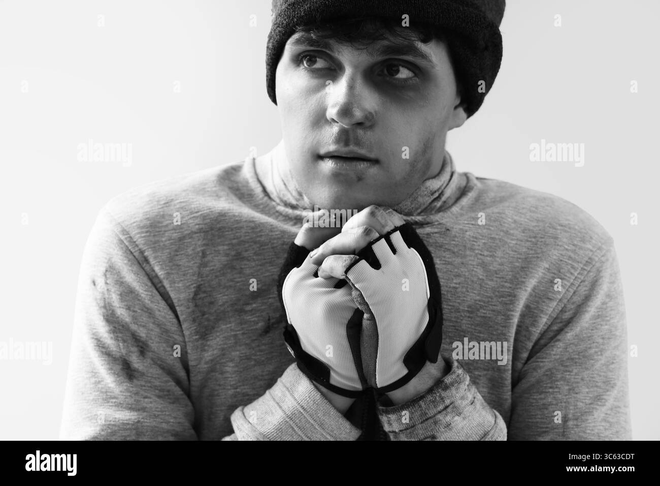 Frozen young homeless man on light background, closeup Stock Photo - Alamy