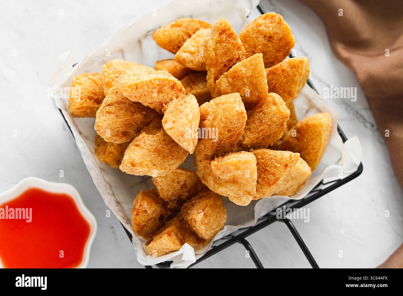 Crispy fried meatballs (Bakso Goreng) in a black wire serving basket ...
