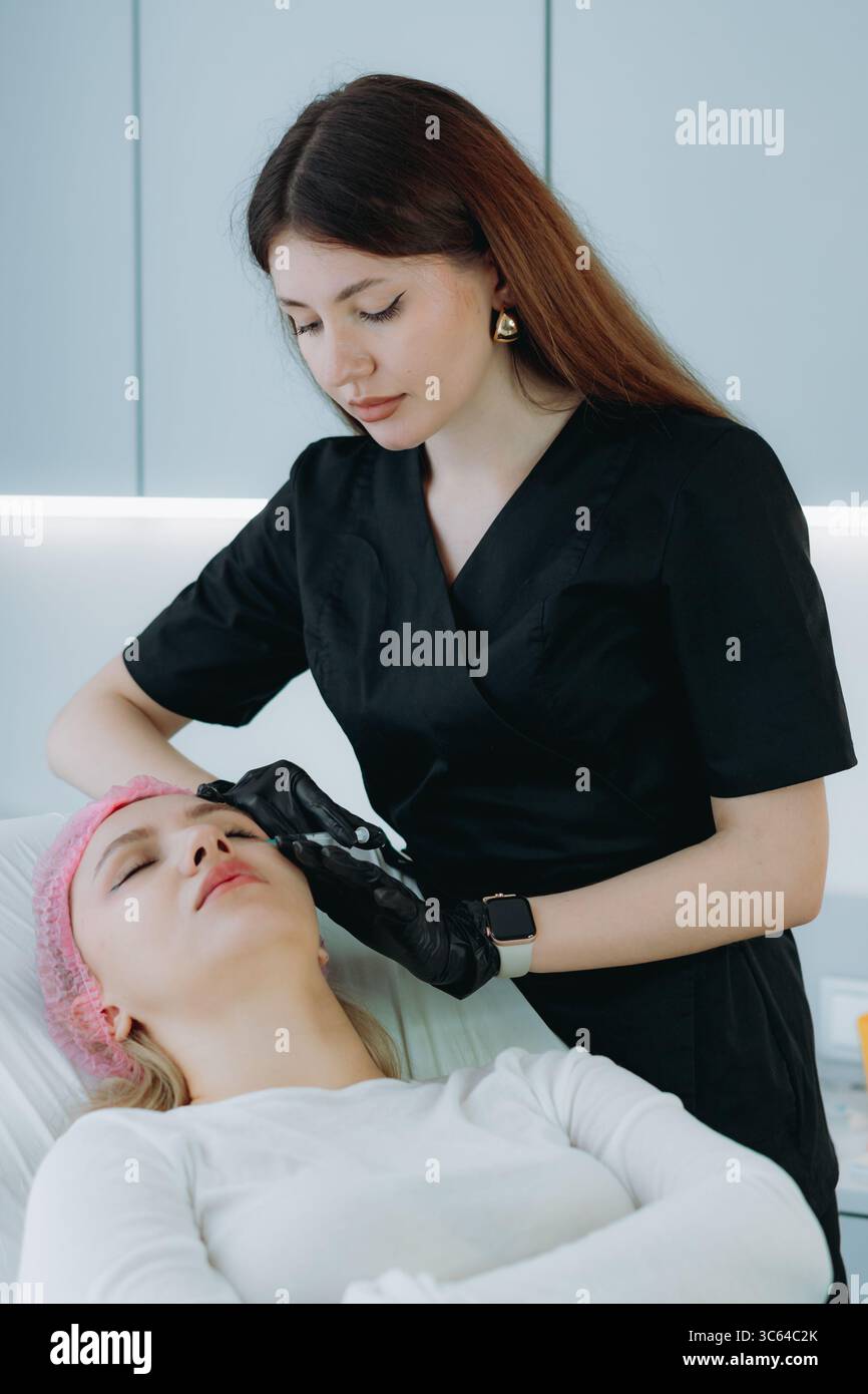 young woman getting an injection procedure in aesthetic clinic. Beauty ...
