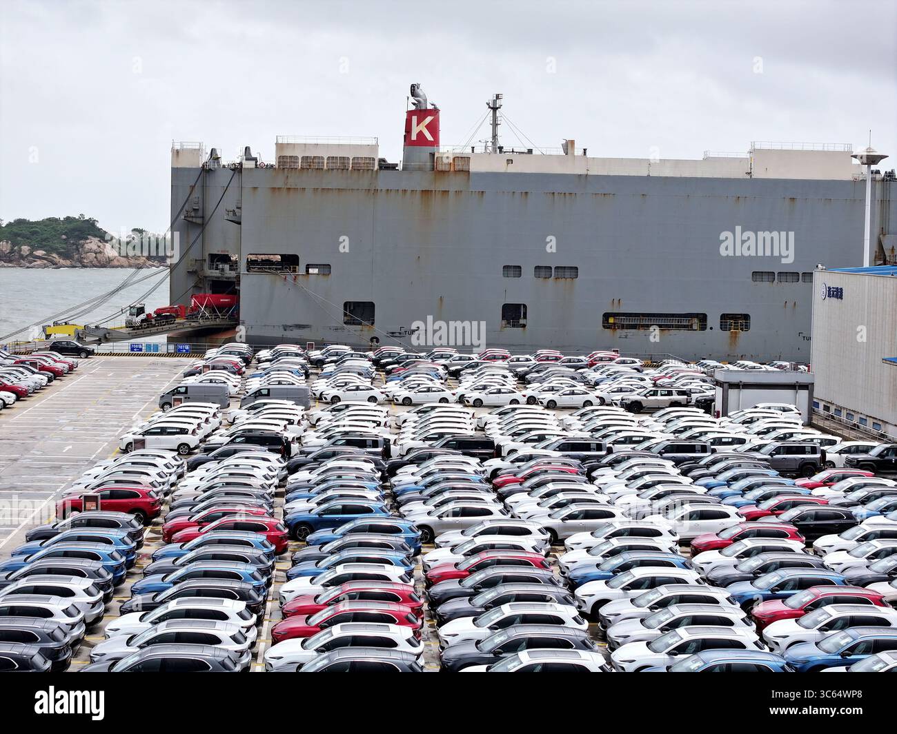 A roll-on/roll-off vessel is parked in a berth loading export vehicles ...