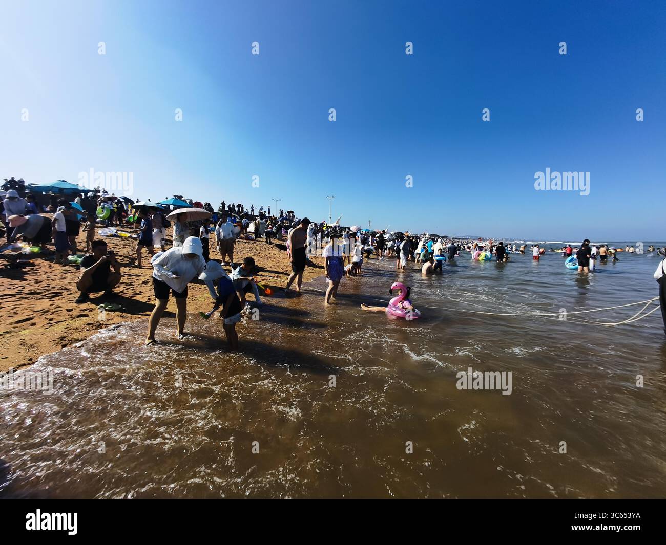 Tourists play at a bathing beach in Rizhao City, east China's Shandong ...