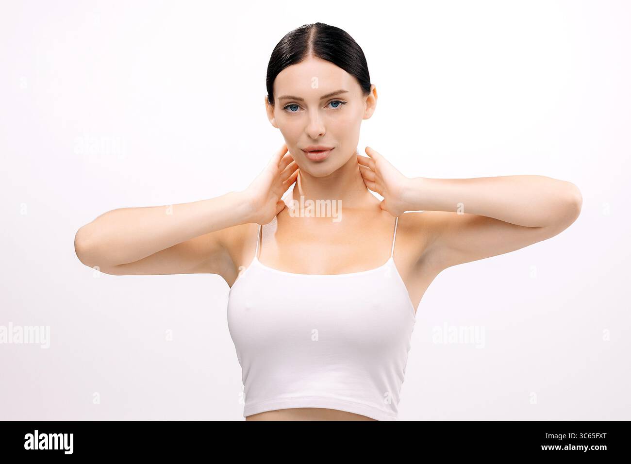 Female model with clear skin is posing against a white background ...