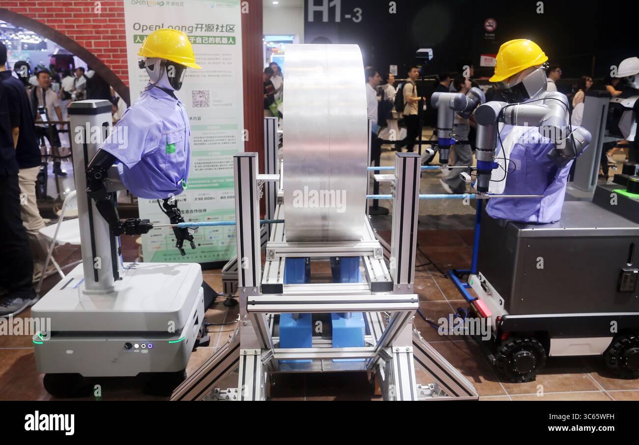 Robots wearing work clothes demonstrated working in factory workshop ...