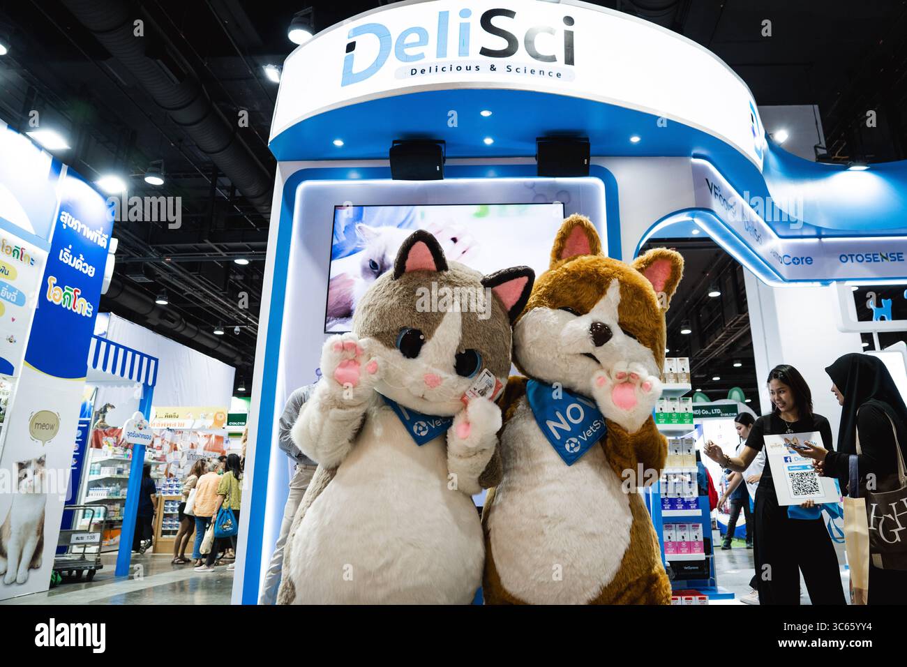 Mascots dressed as a cat and a dog pose for photos in front of the ...