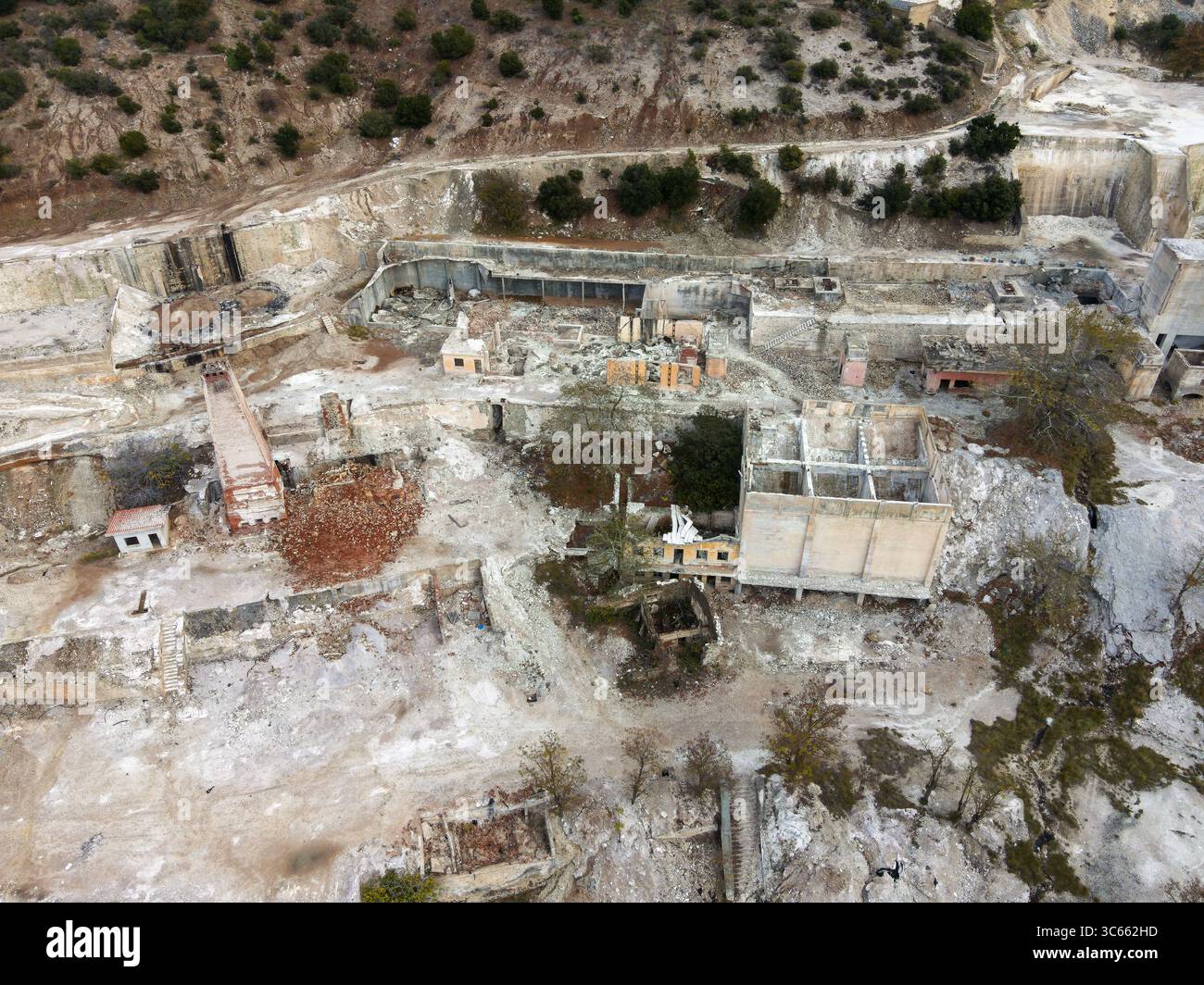 Aerial view of a quarry site with exposed rock faces and industrial ...