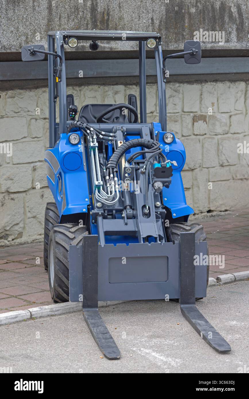 Mini Loader Vehicle Machine With Front Mounted Forks Stock Photo - Alamy