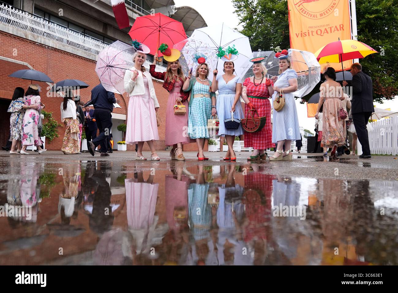 Milliner Anna Gilder (third right) and friends pose for photographs ...