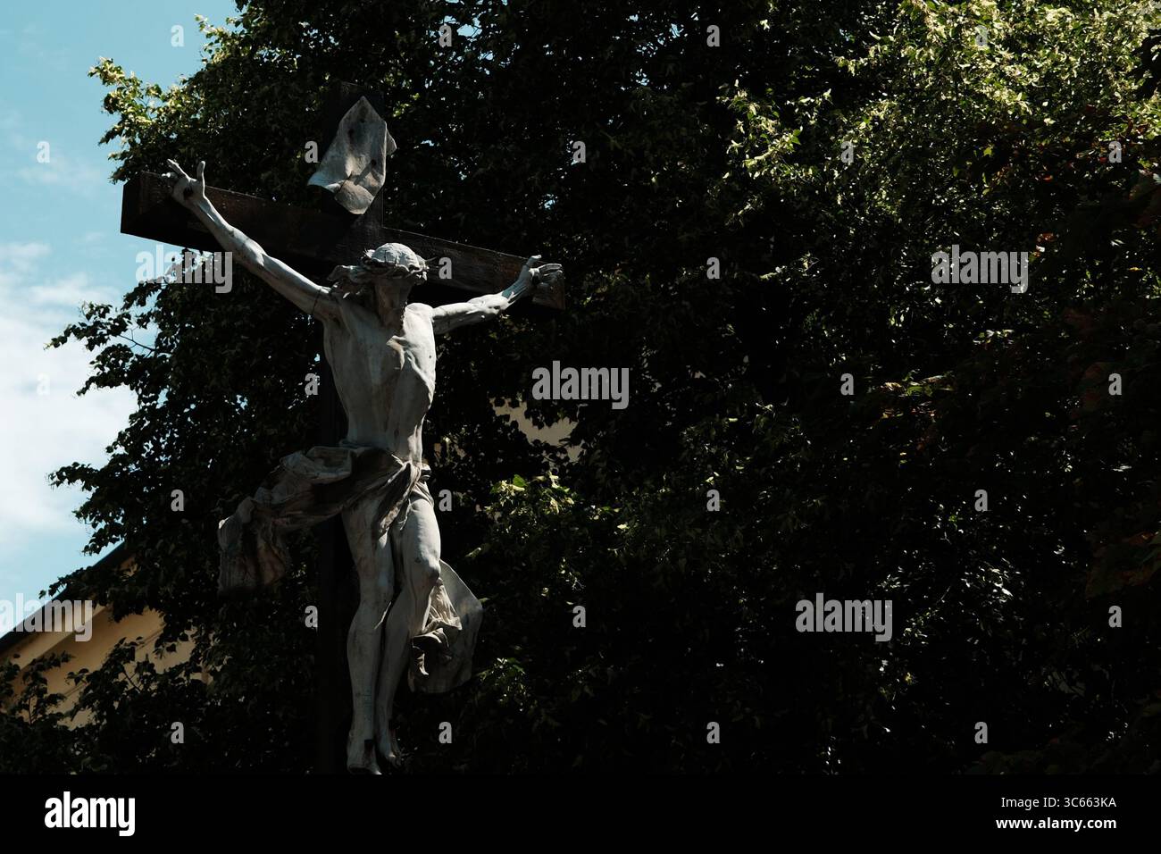 Sculpture of crucified Jesus on a wooden cross among trees in Apatin ...