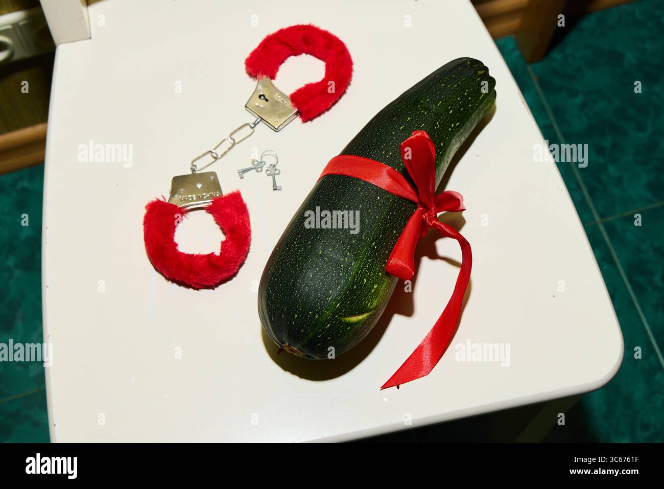 A Quirky Zucchini Styled with Handcuffs and a Colorful Ribbon on a ...