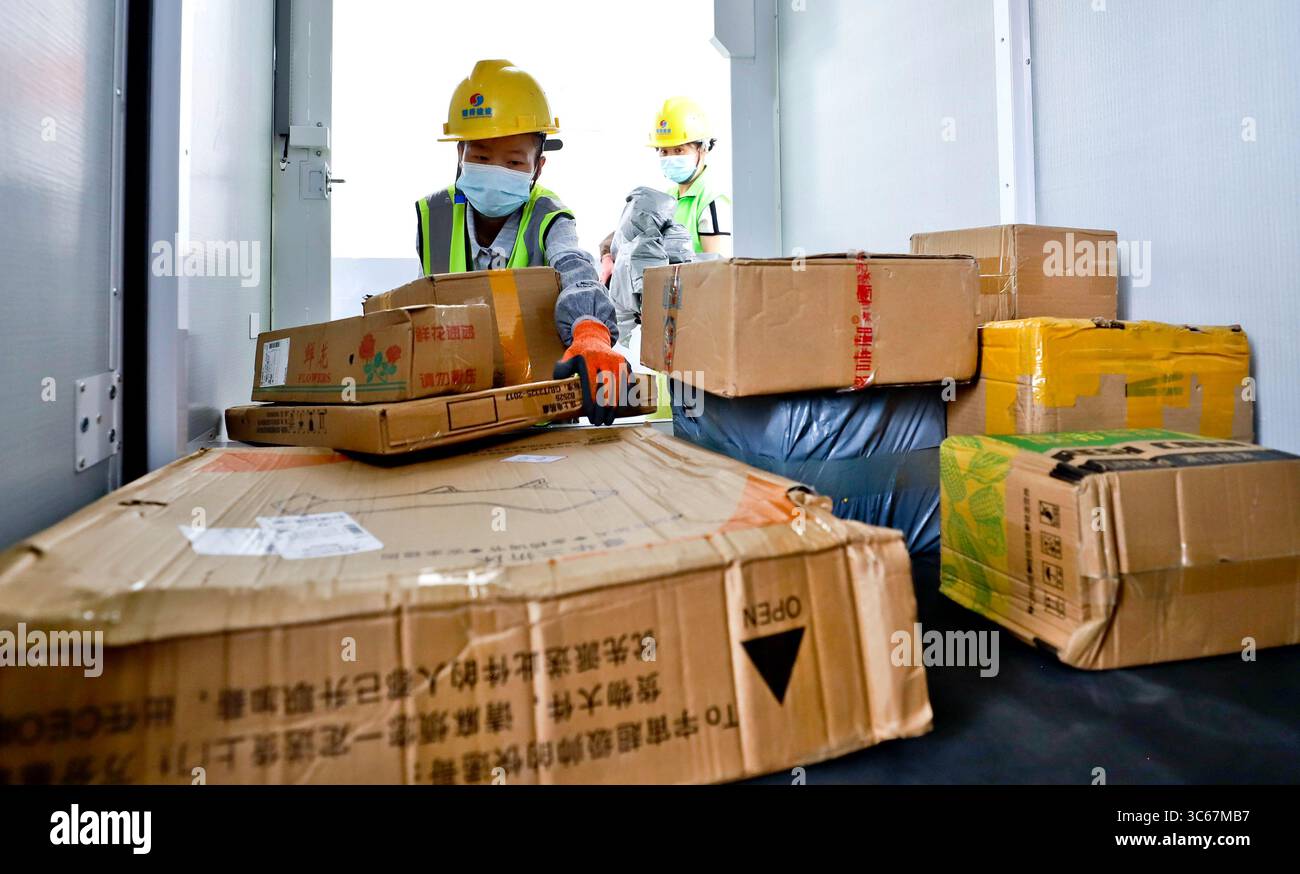 Staff members are loading express packages into unmanned delivery ...
