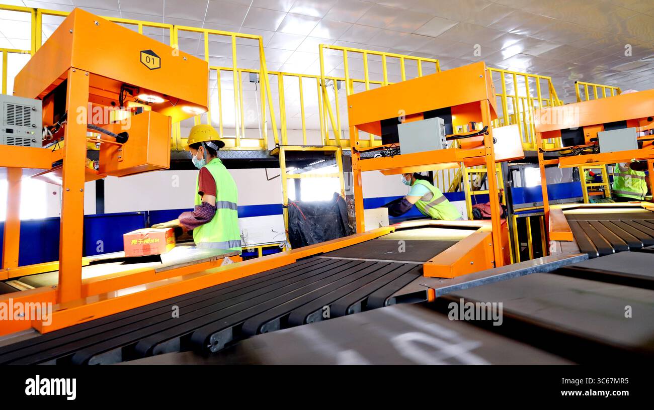 Staff members are sorting the parcels delivered by unmanned express ...