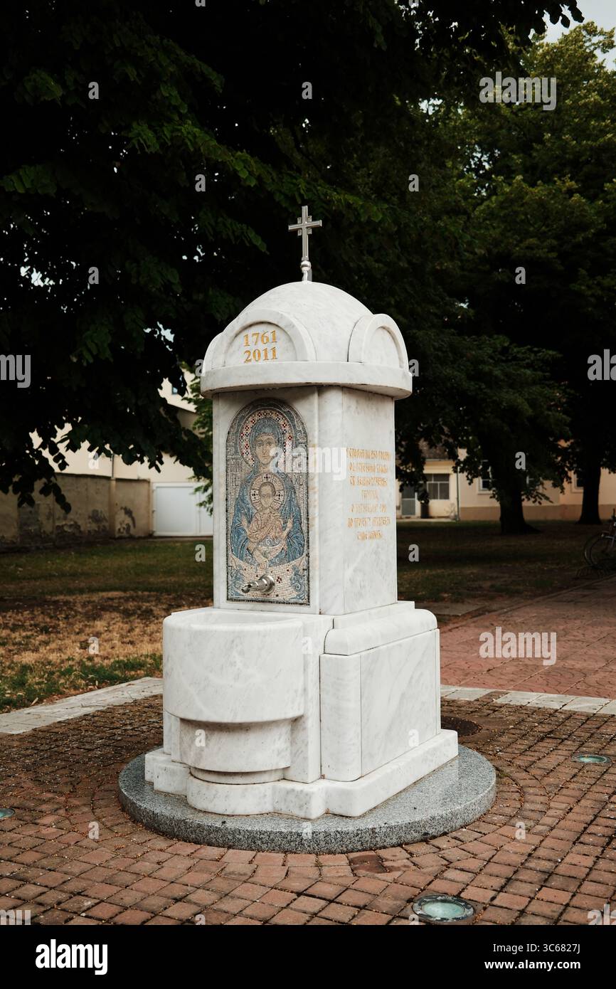 White marble drinking fountain with an icon of the Virgin Mary and ...