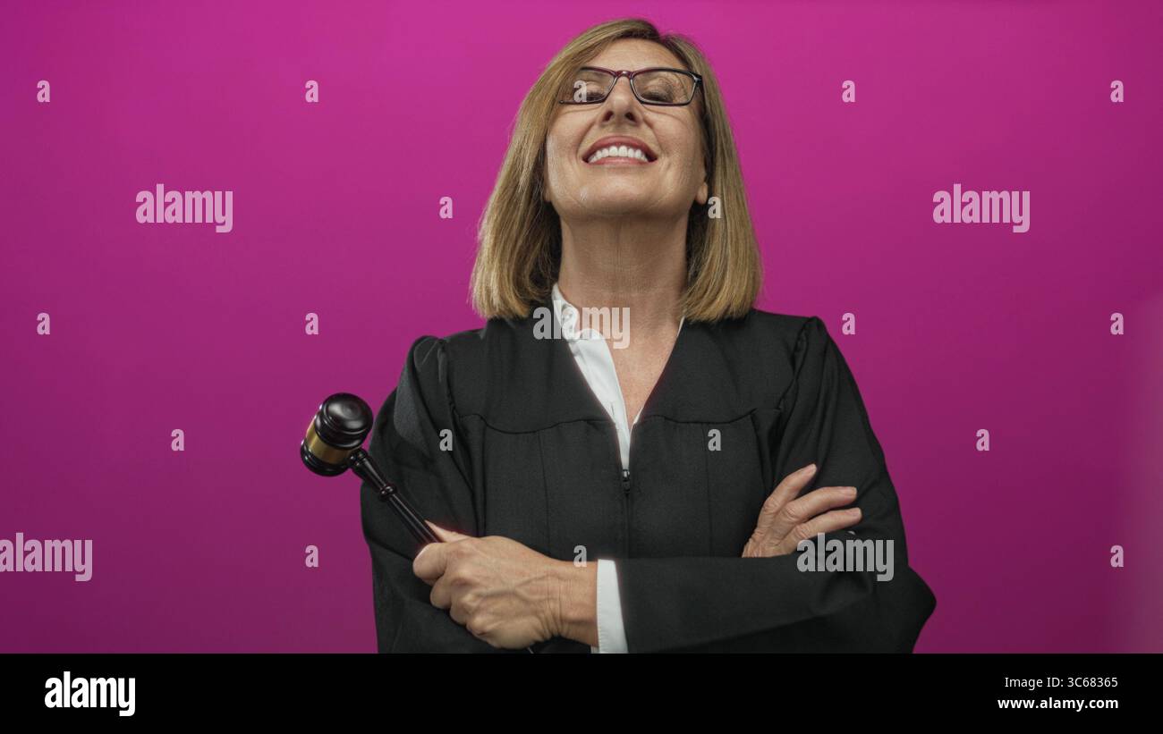 Middle age judge woman wearing black robe smiling while holding gavel ...
