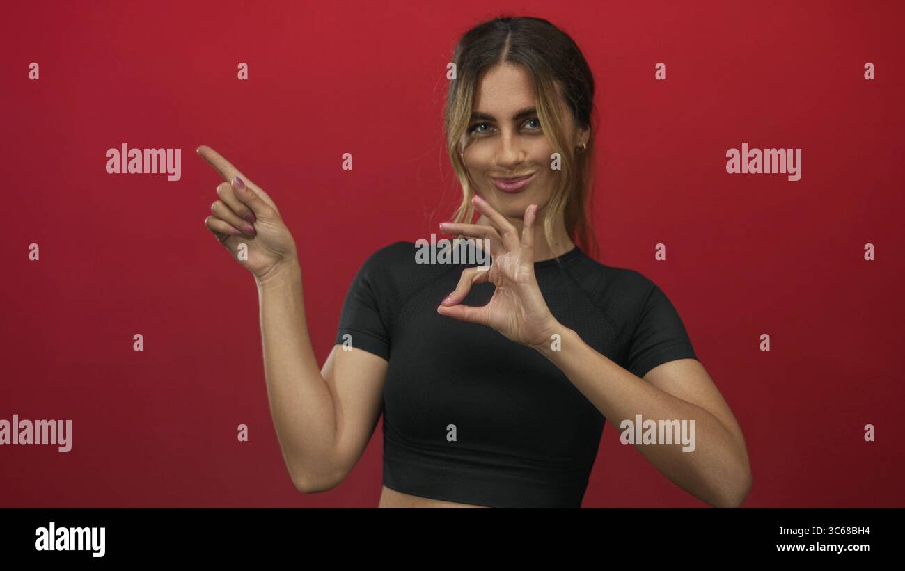 Woman pointing finger left with steady gaze and wearing black top in ...