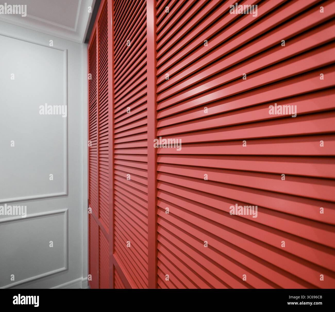 Red louver panel inside a white room. Perspective view of pale red ...