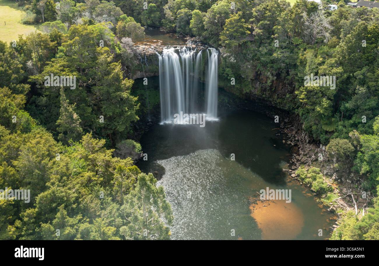Aerial view of the cascading Whangarei Falls plunging into a dark pool ...