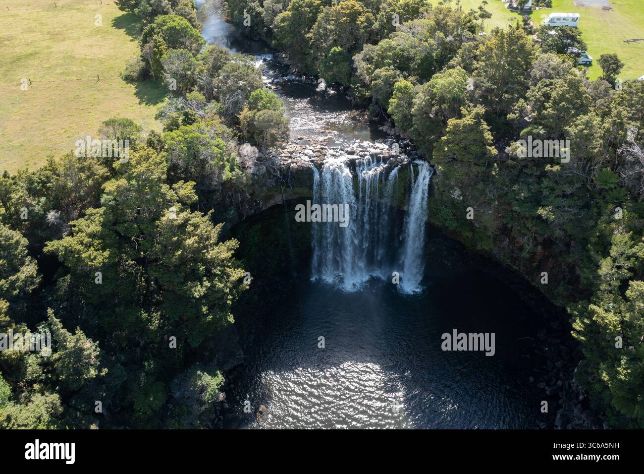 Aerial view of the cascading waterfall plunges into a dark pool ...