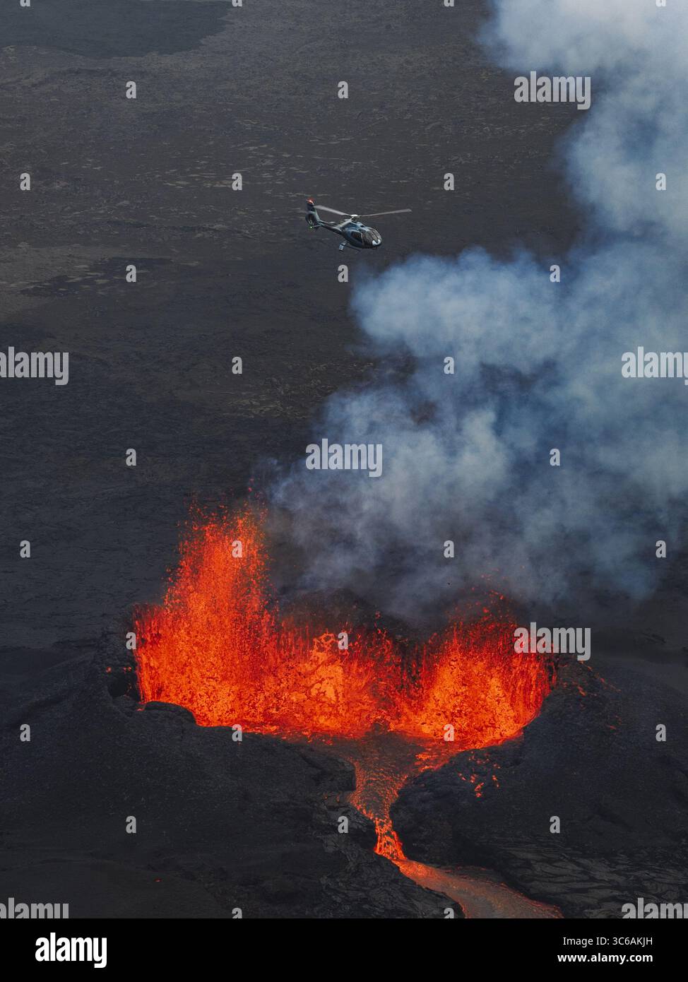 Aerial view of a helicopter flying above a volcanic eruption, with ...