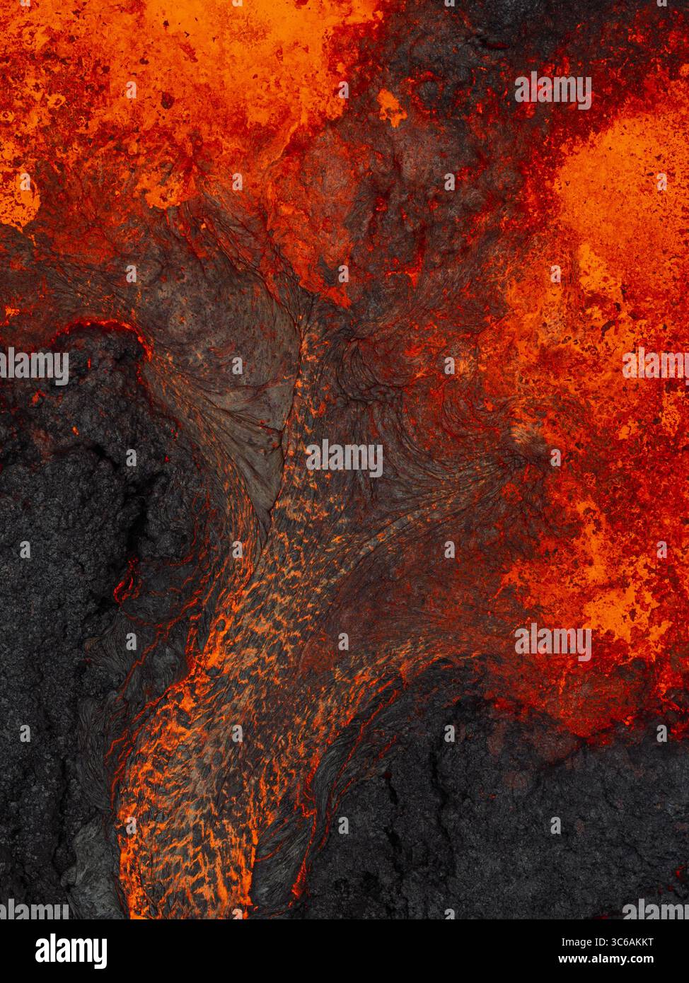 Aerial view of molten lava flowing like fiery rivers across the dark ...