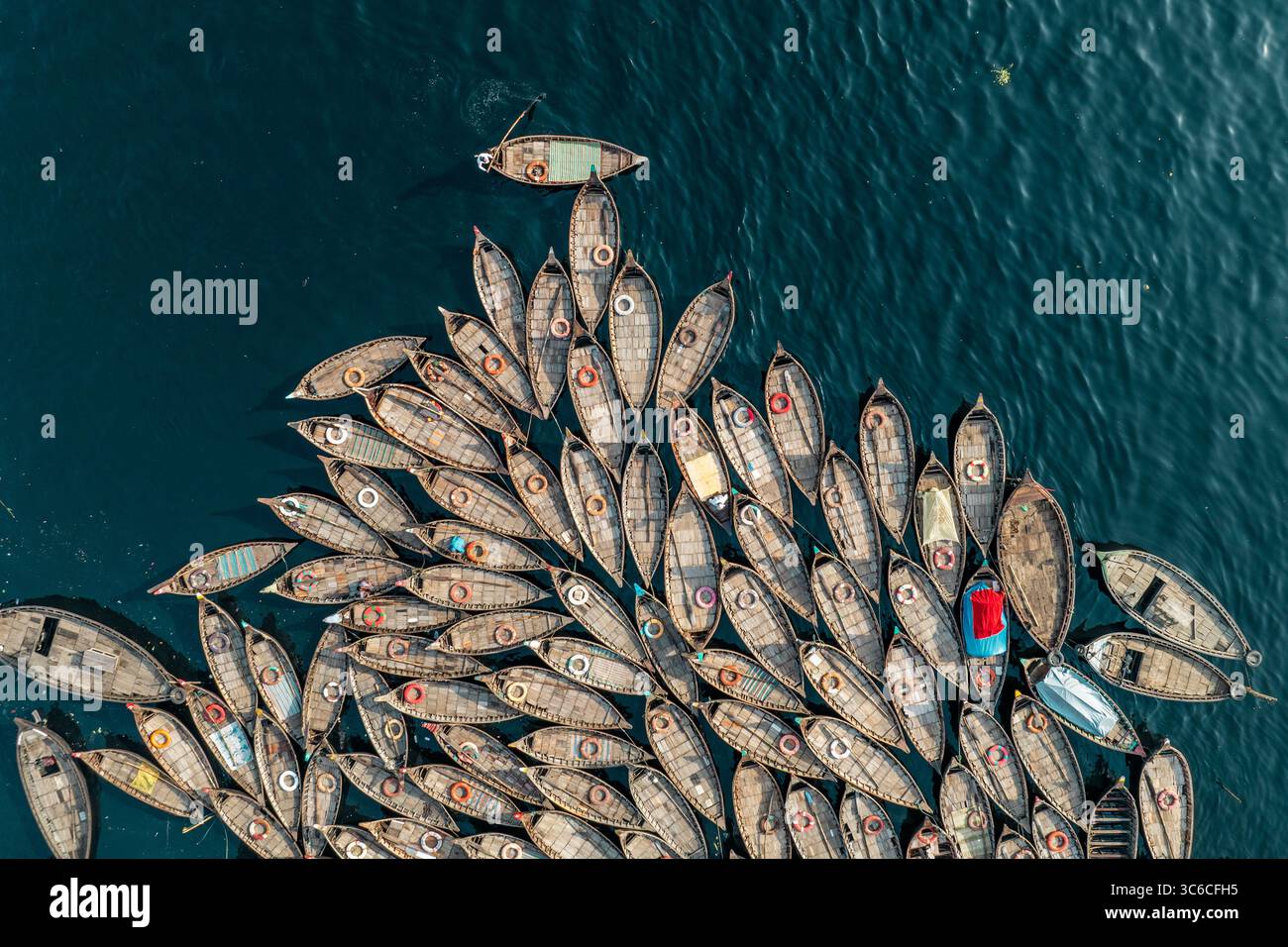 Aerial view of wooden boats clustered tightly together on the rippling ...