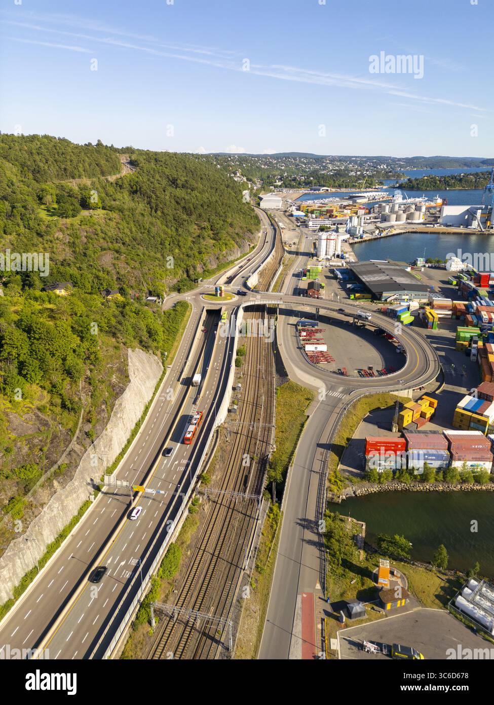 Aerial view of the E18 highway curving alongside a rail line ...