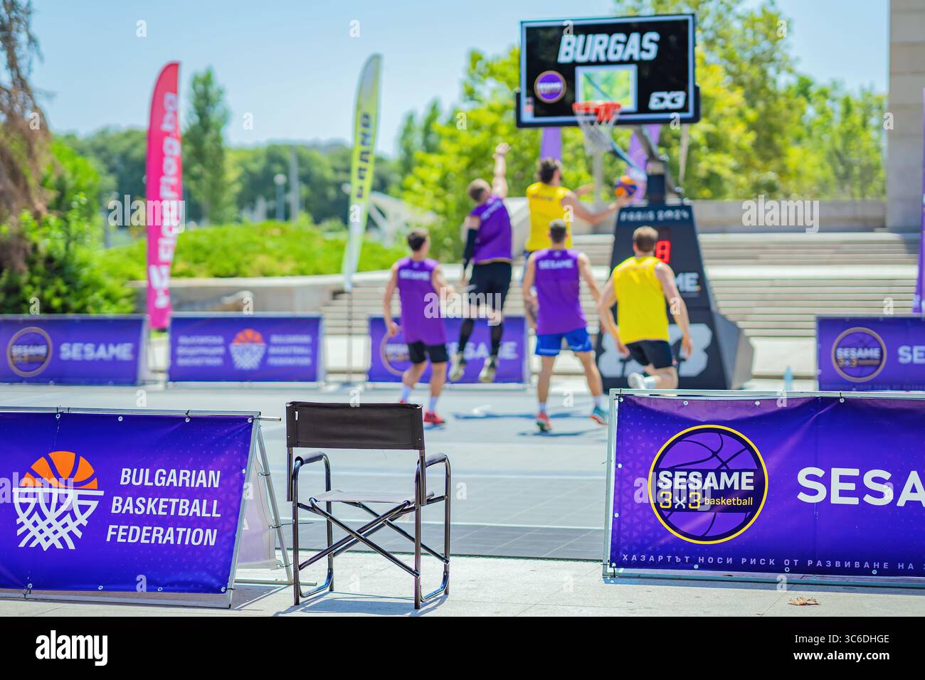Sporting moment at street basketball tournament. Players in purple and ...