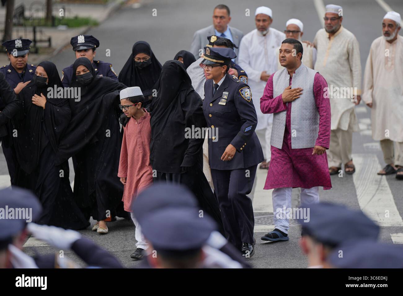 Family members of officer Didarul Islam walk behind the hearse after ...