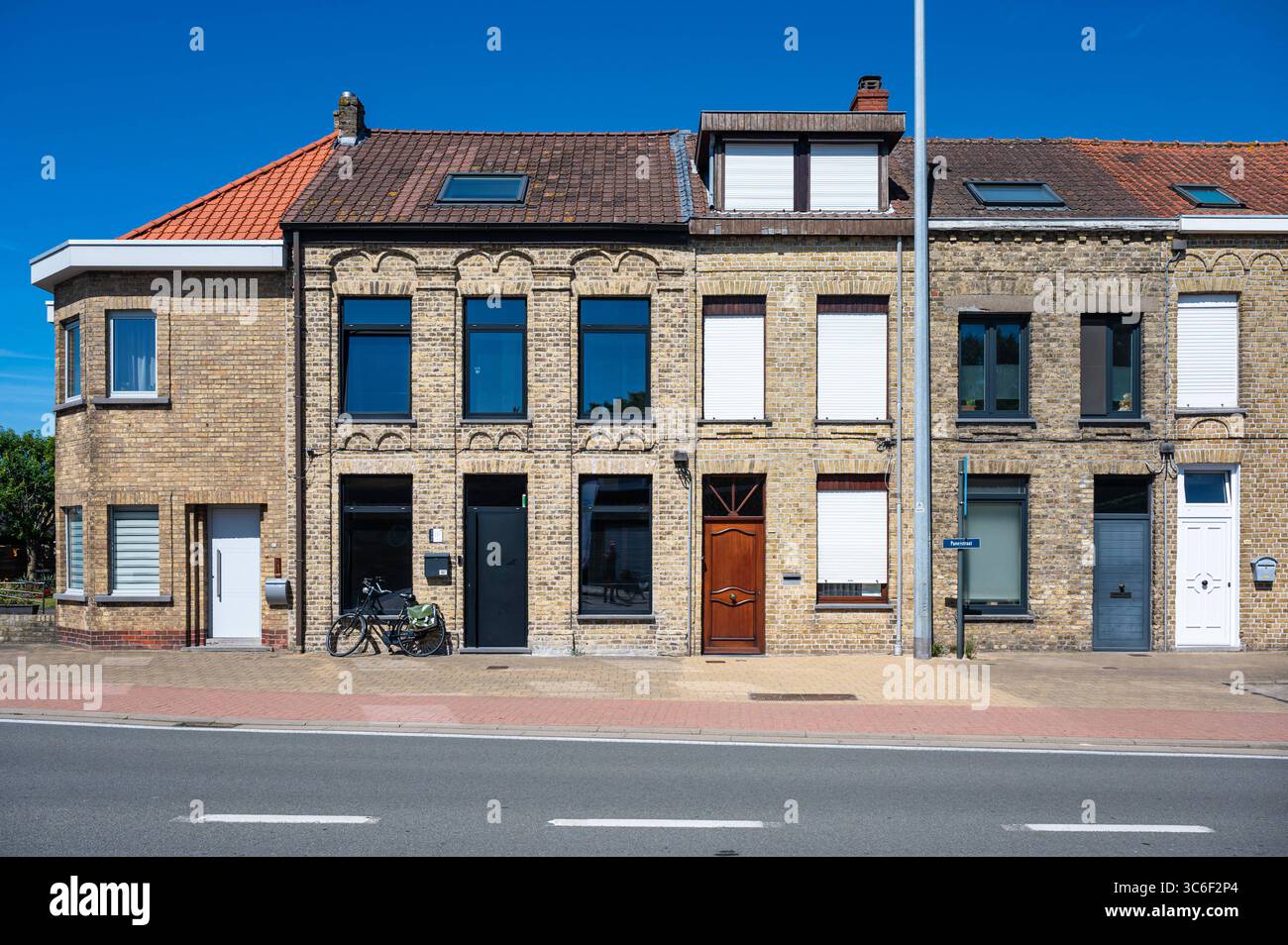 Facade of regular residential houses in a row in Veurne, West Flemish ...
