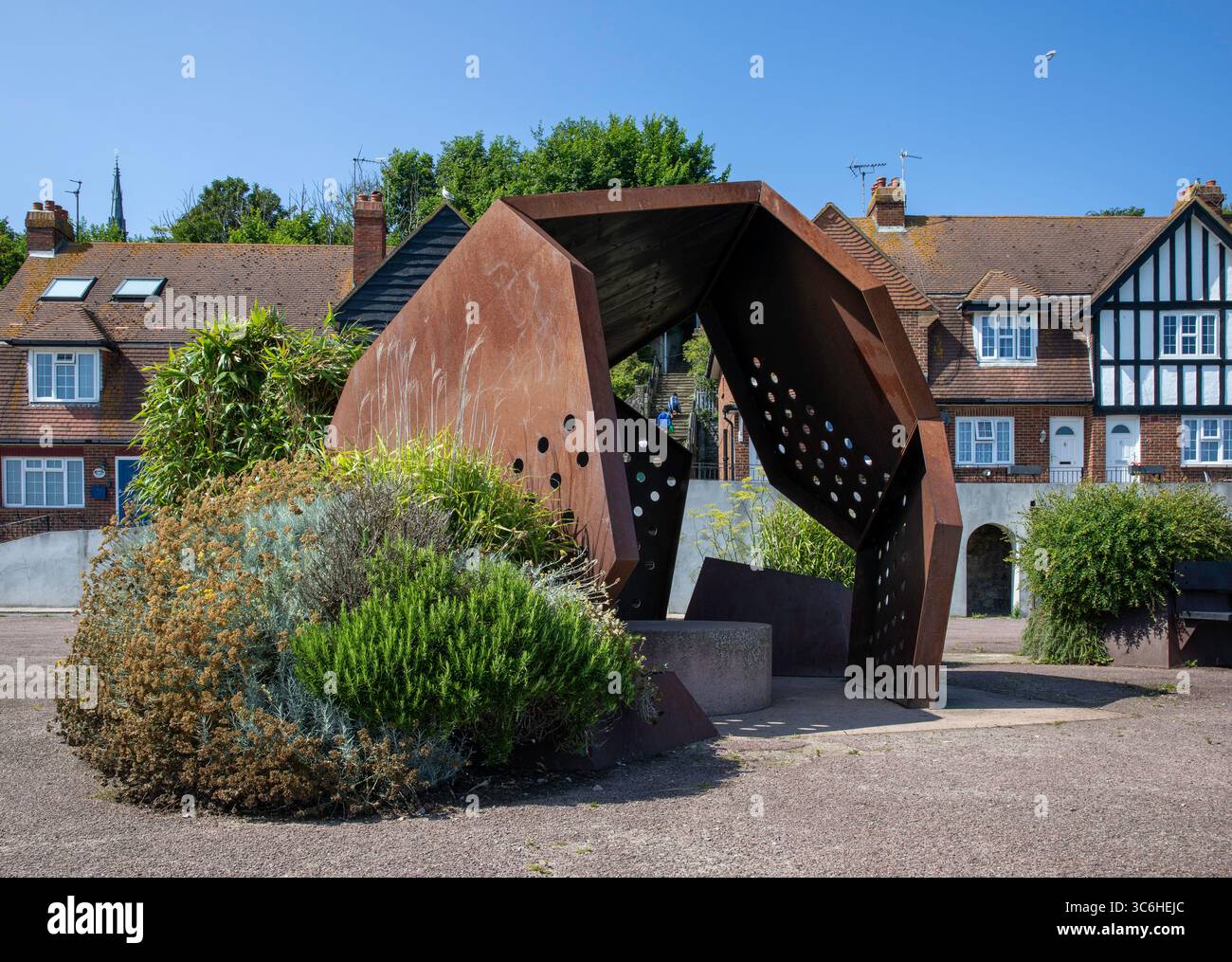 An artwork which is also a shelter and bench is this metal structure ...