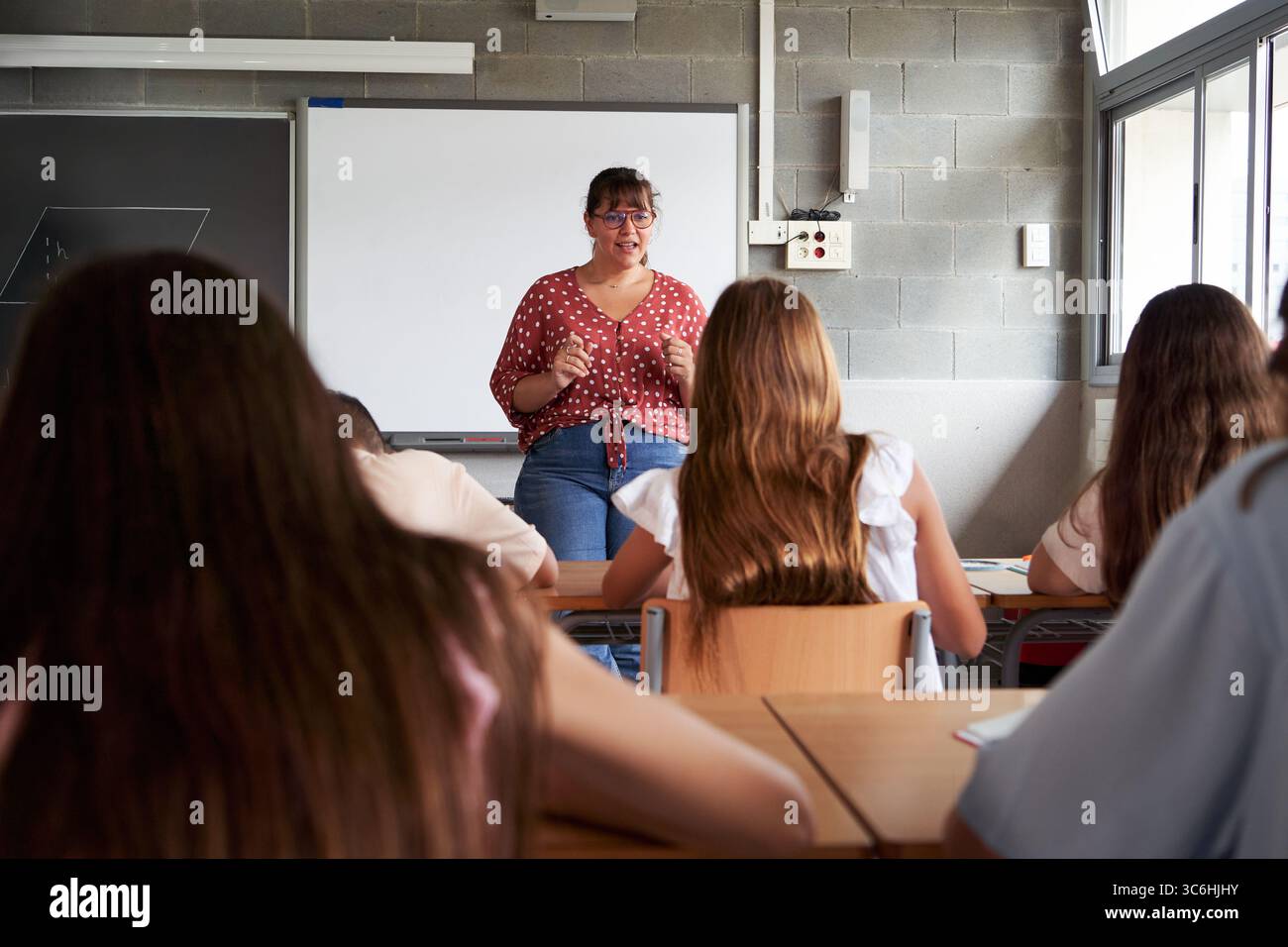 High school teacher explaining lesson to students in classroom Stock ...