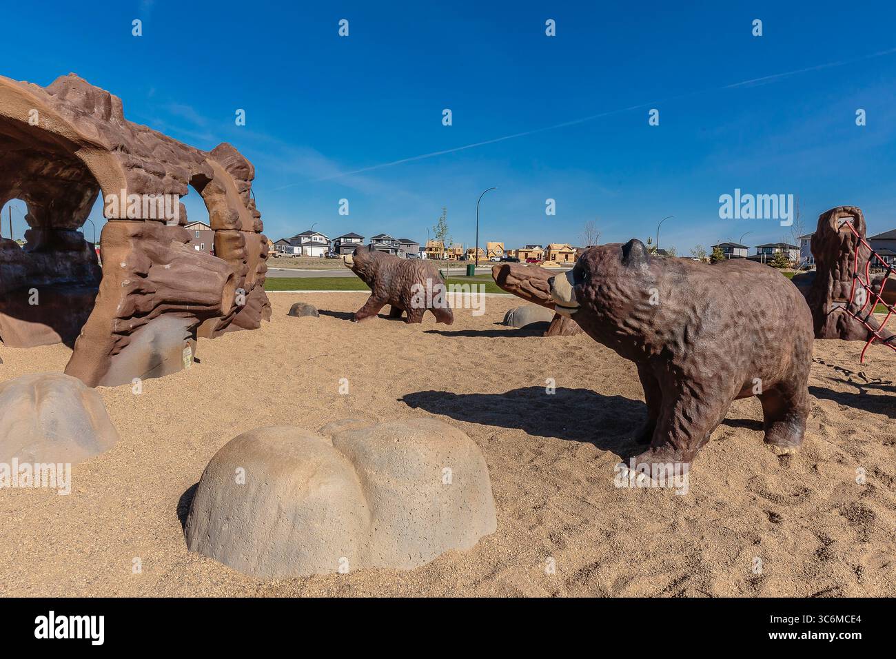 Group of bear statues are sitting on a sandy area. The bears are made ...