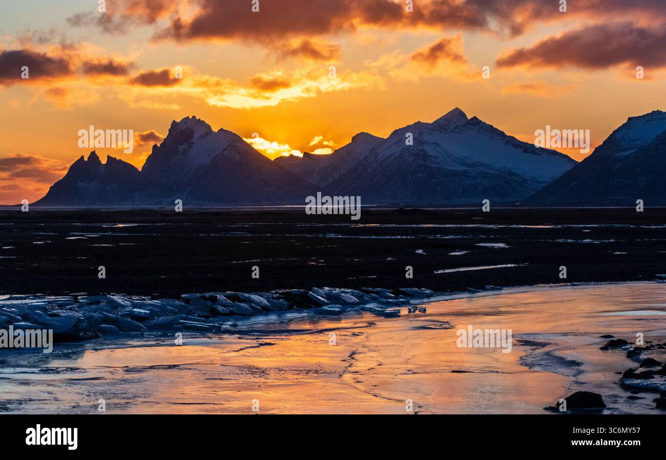 Outdoor scene depicting an icy river against a backdrop of snowy ...