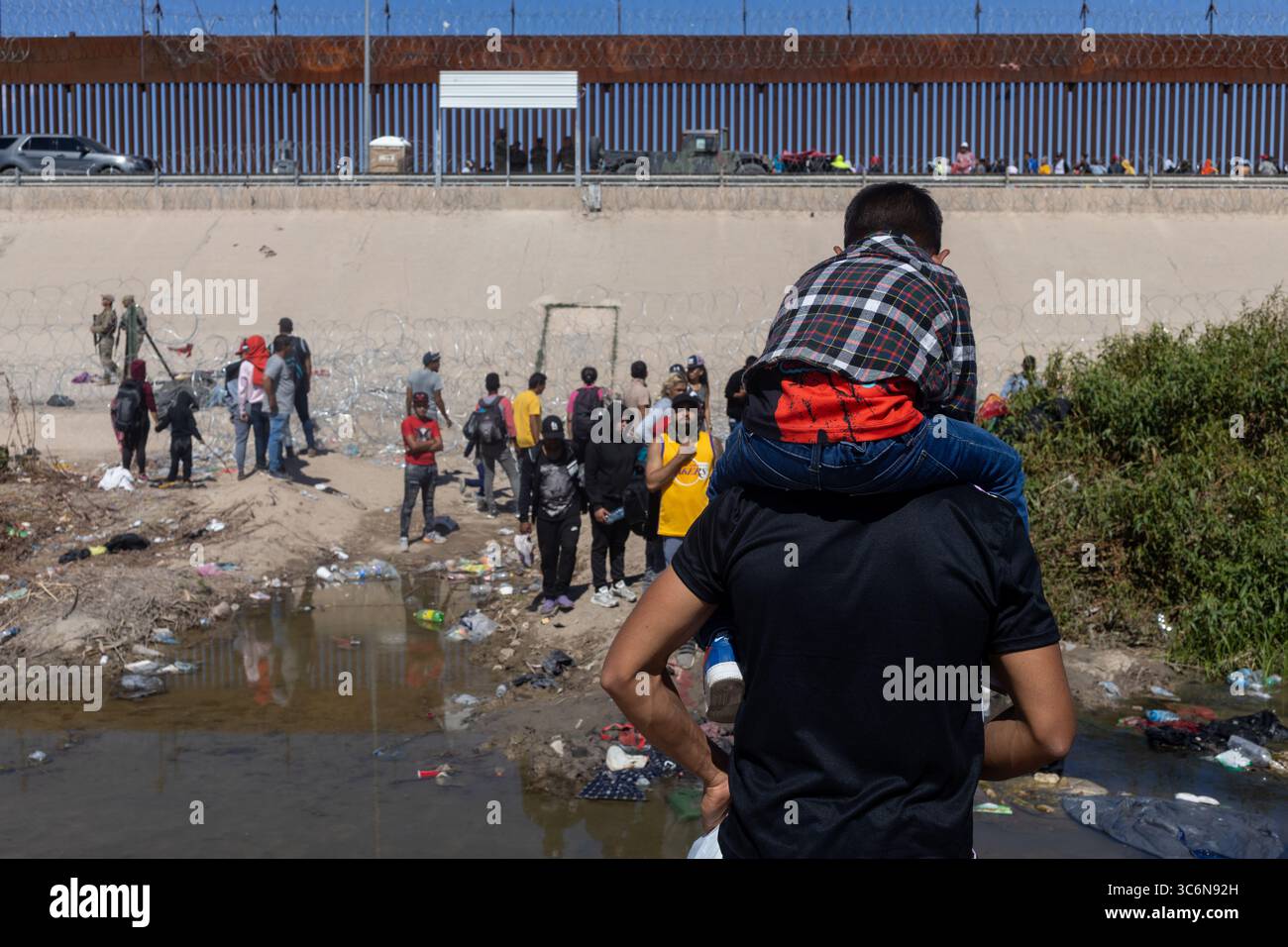 Crowd at Ciudad Juarez border, adult carrying child observes Stock ...